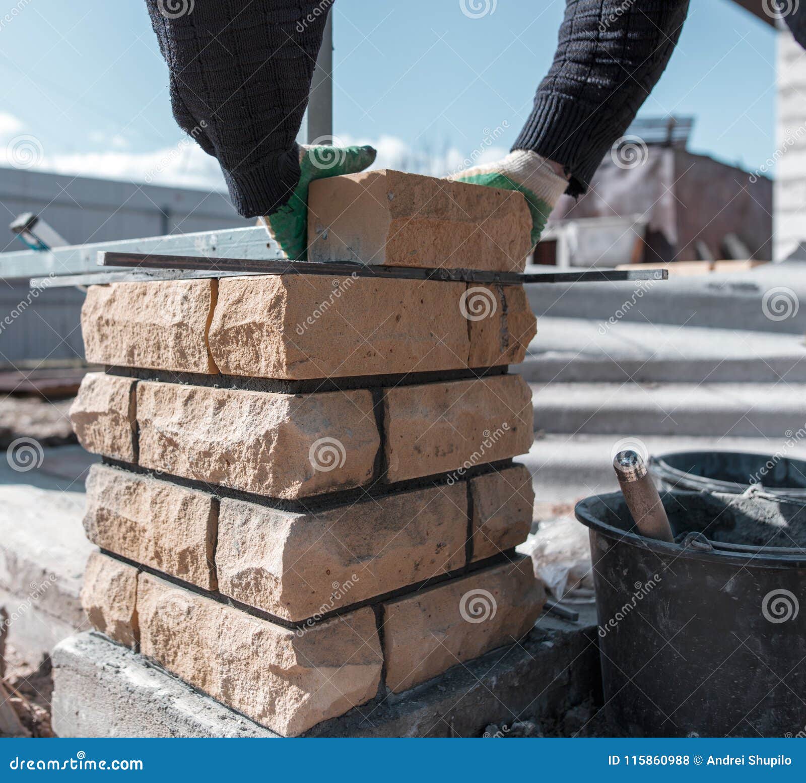 Man Builds a Brick Wall at a Construction Site Stock Photo - Image of ...