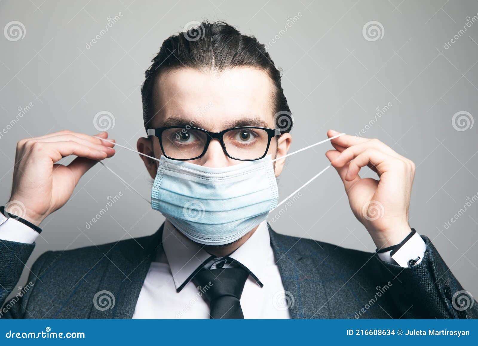 A Man in a Business Suit Puts on a Mask Stock Photo - Image of mask ...
