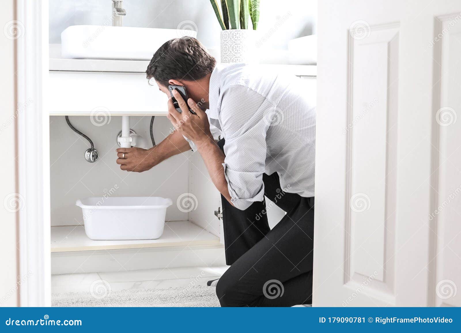 Man Calling Plumber in Front of Water Leaking from Sink Pipe Stock ...