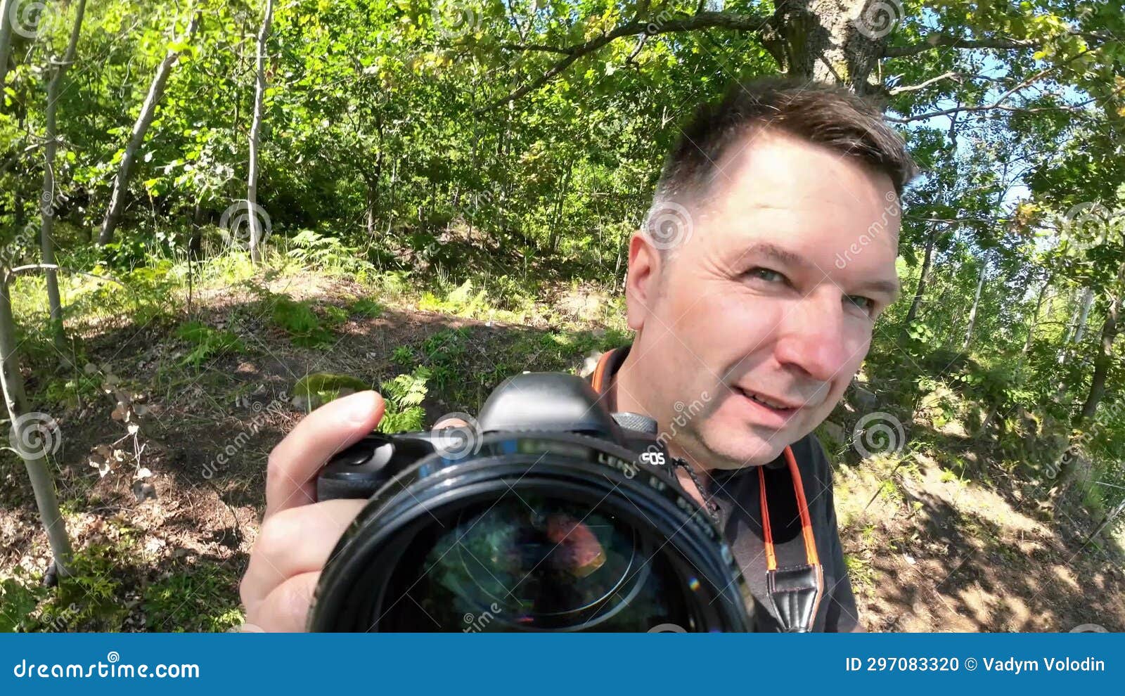 A Man with a Camera Makes His Way through the Trees To Get Some Shots ...