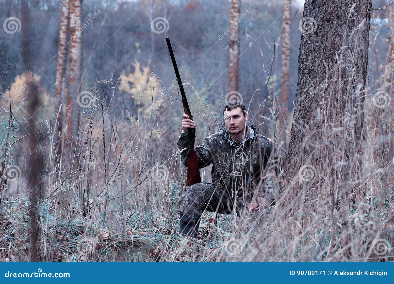 A Man in Camouflage and with a Hunting Rifle in a Forest on a Sp Stock ...