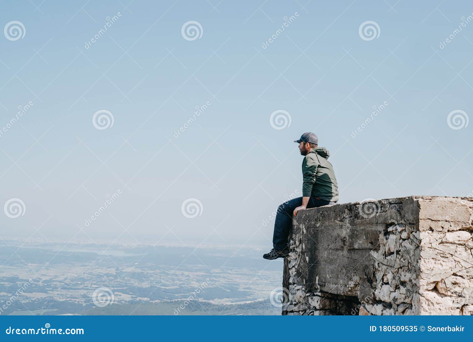 Man with Cap Sitting Backside Looking View from Top of Building. Stock ...