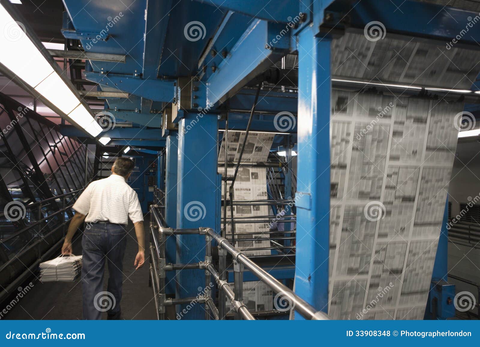 Man Carrying Newspaper Stack in Factory Stock Photo - Image of bundle ...