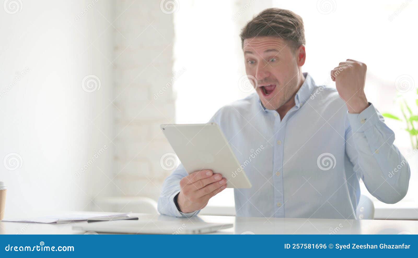 Man Celebrating Success on Tablet in Office Stock Photo - Image of male ...