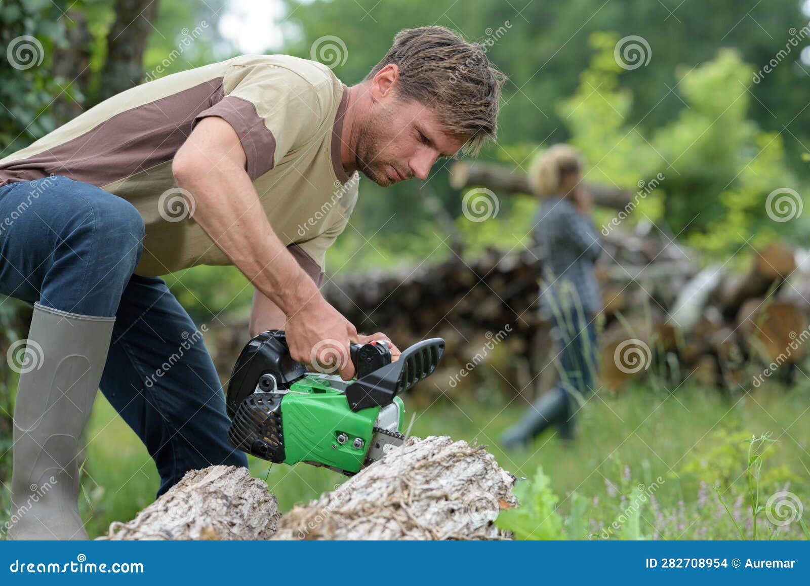 Man chainsawing tree trunk stock photo. Image of dirt - 282708954