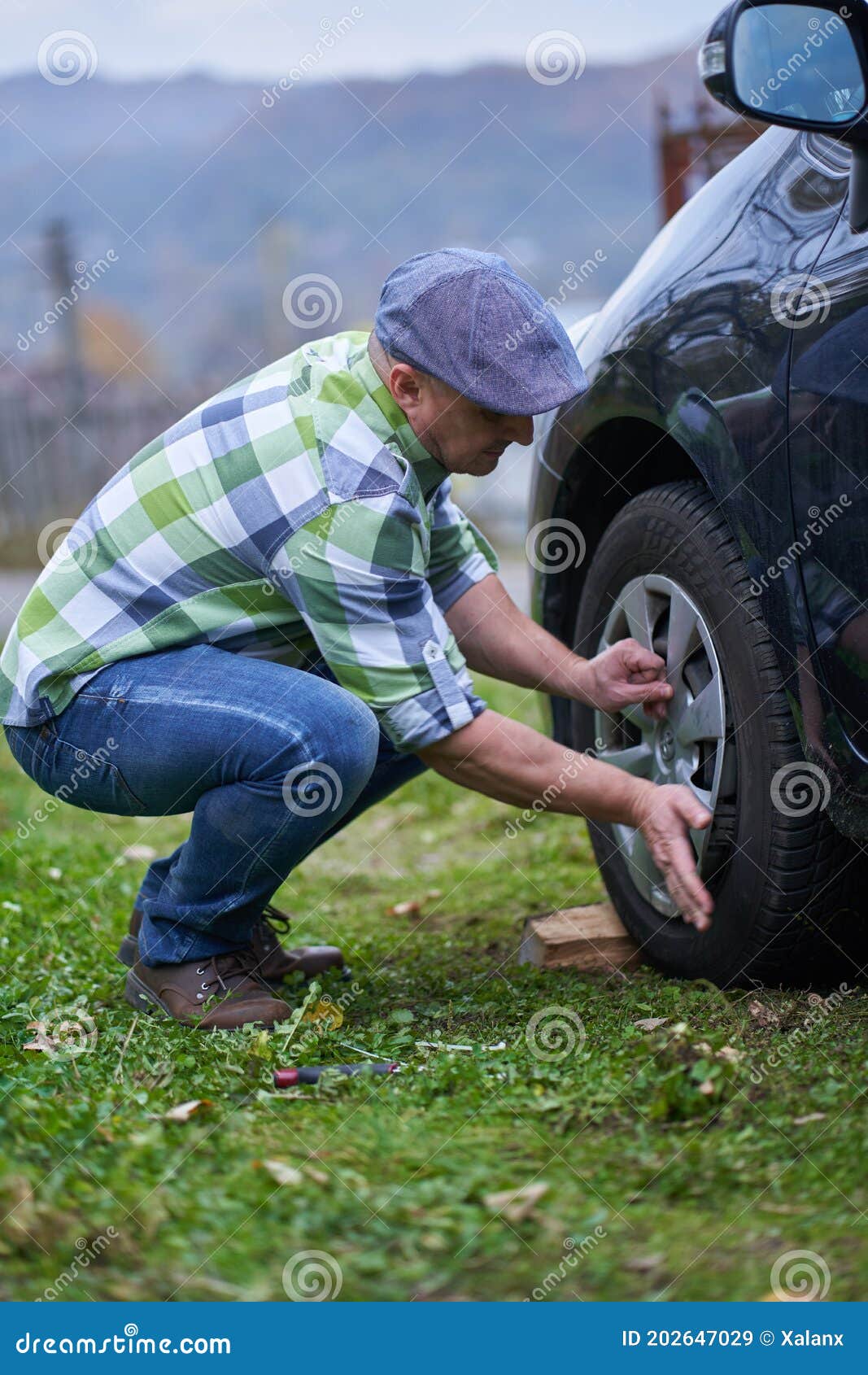 Man changing a flat tyre stock image. Image of caucasian - 202647029