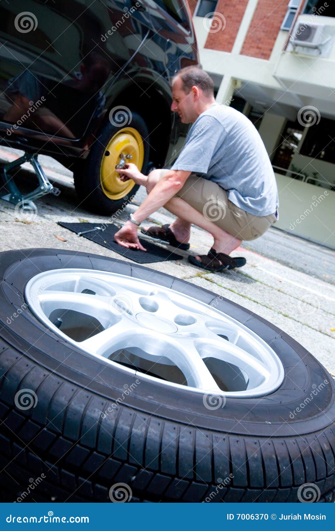 Man changing his car tyre stock photo. Image of wheel - 7006370