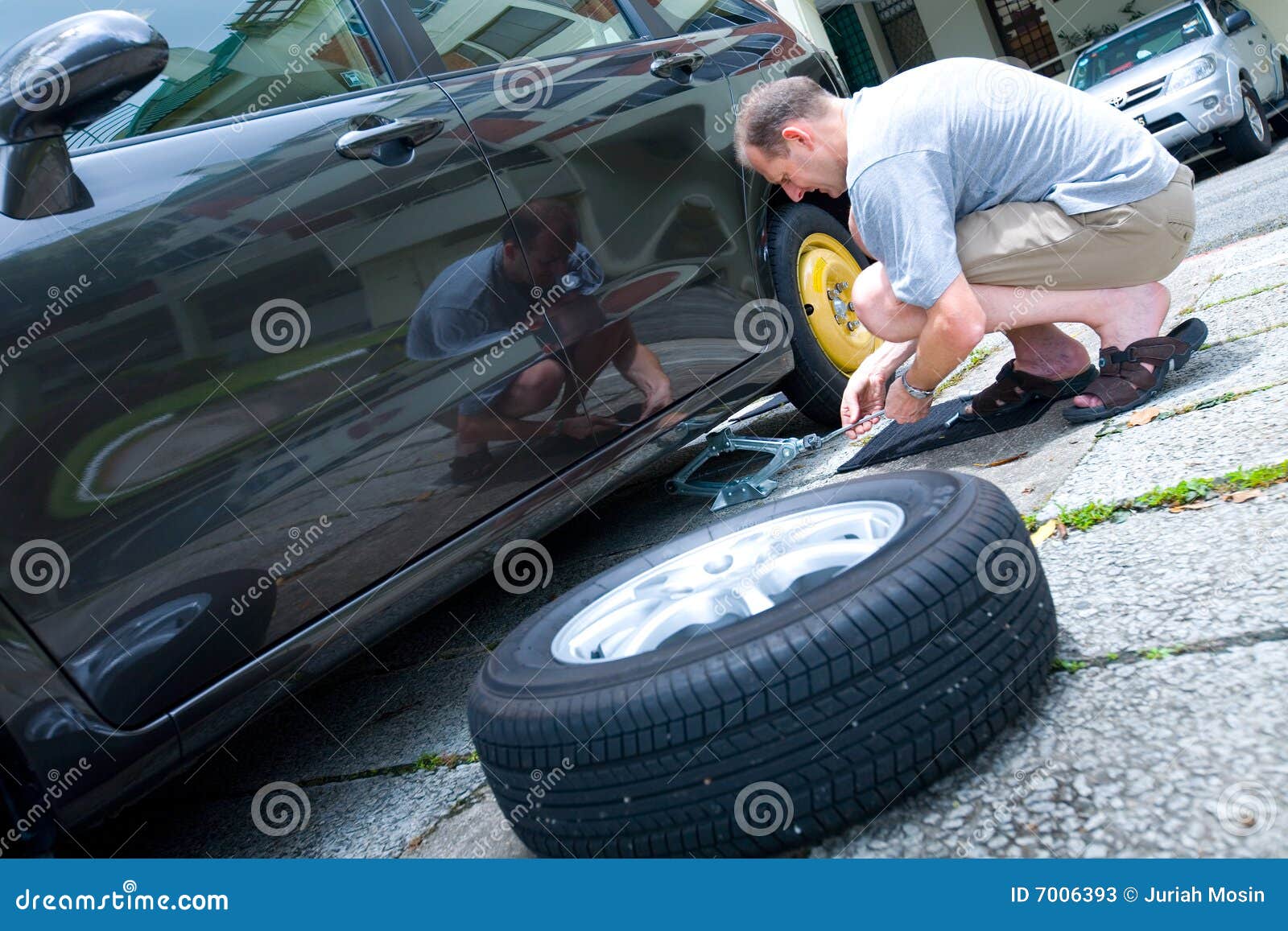 Man changing his car tyre stock image. Image of rubber - 7006393