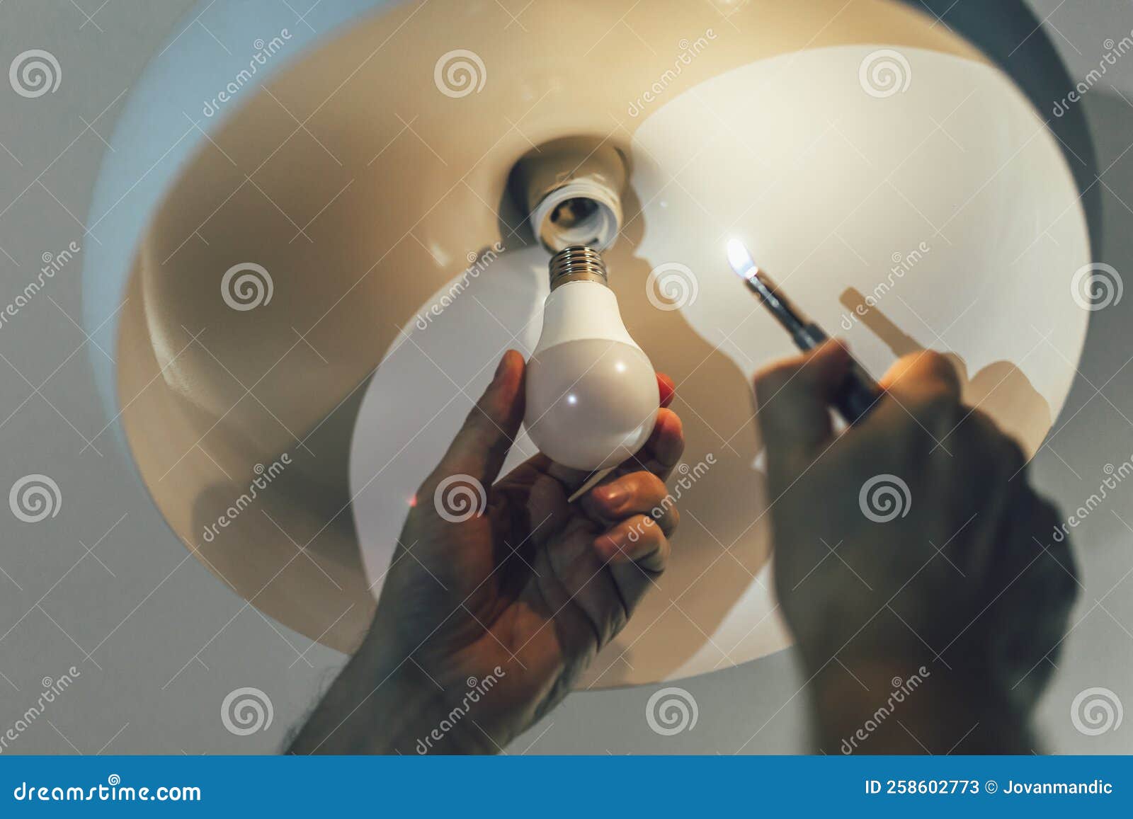 Man Changing a Light Bulb in His Home Stock Image - Image of ...