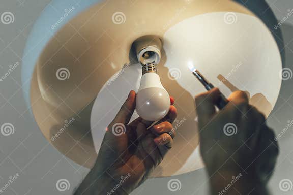 Man Changing a Light Bulb in His Home Stock Image - Image of ...