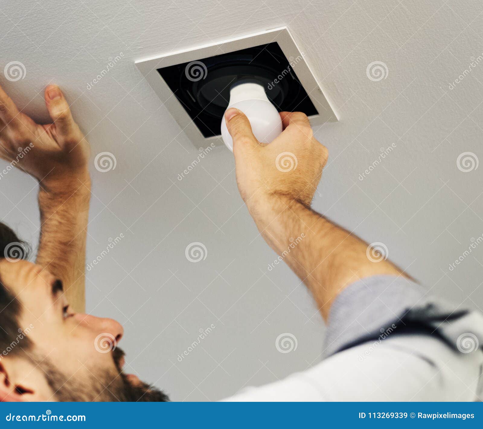 Man changing a light bulb stock image. Image of installation - 113269339