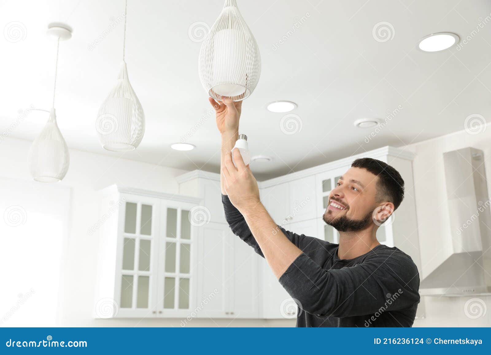 Man Changing Light Bulb in Lamp at Home. Space for Text Stock Photo ...