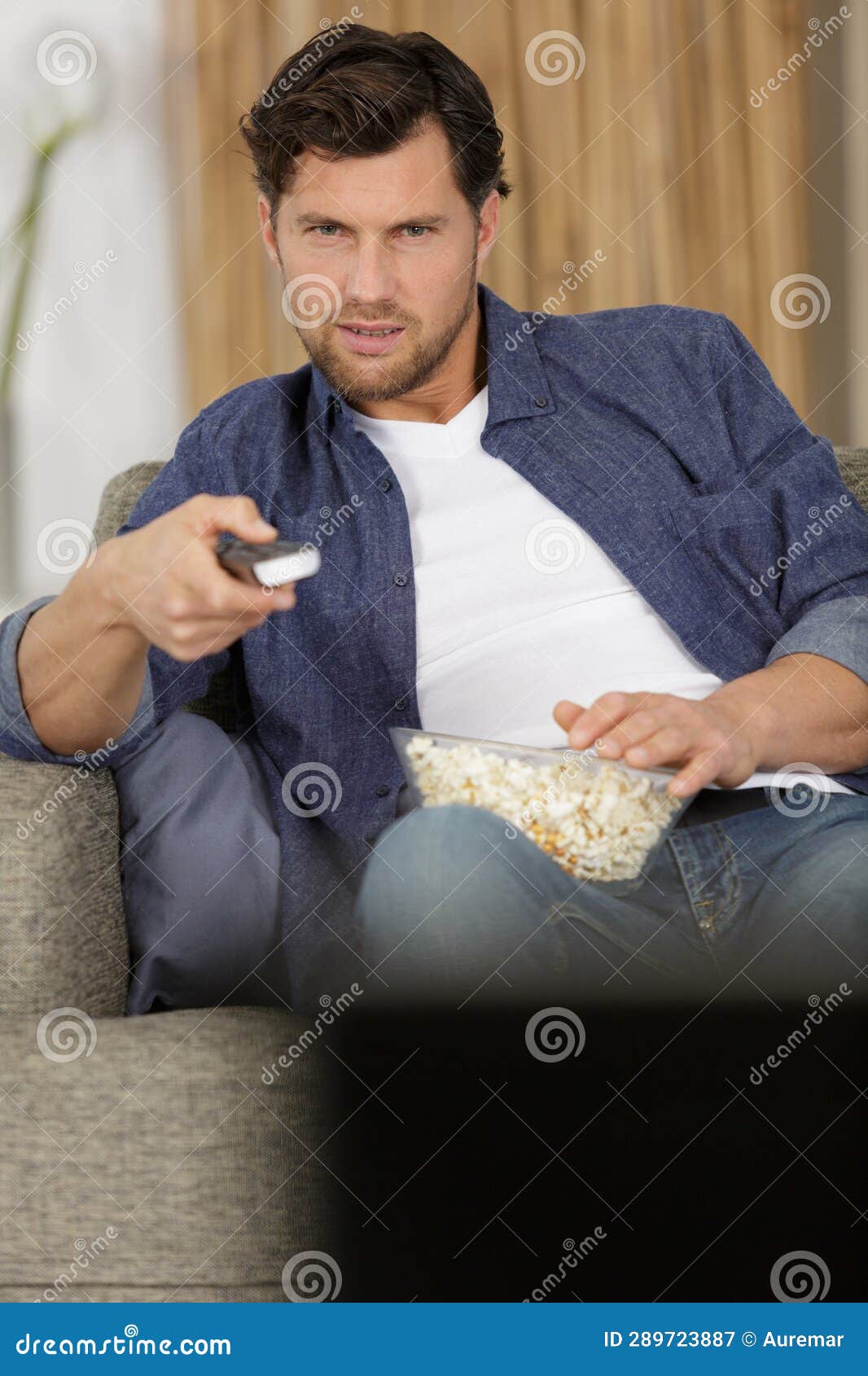 Man Changing Tv Channel with Remote and Eating Popcorn Stock Image ...
