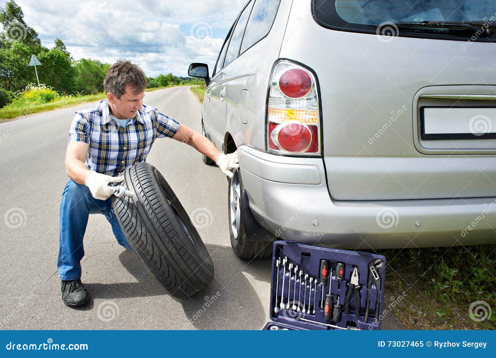Man changing wheel of car stock image. Image of road - 73027465