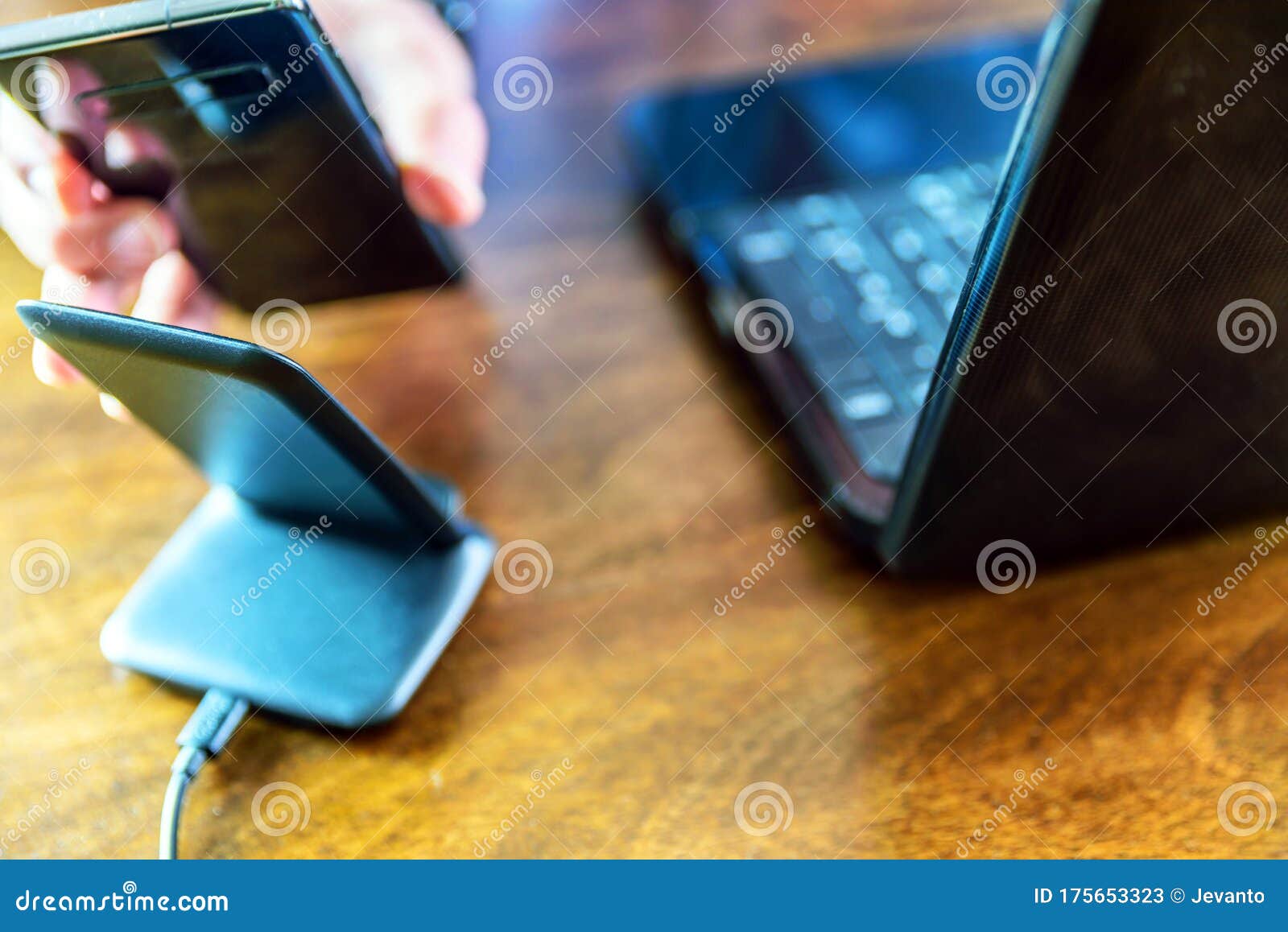Man Charging Smartphone Using Wireless Charging Stand at Home Office ...