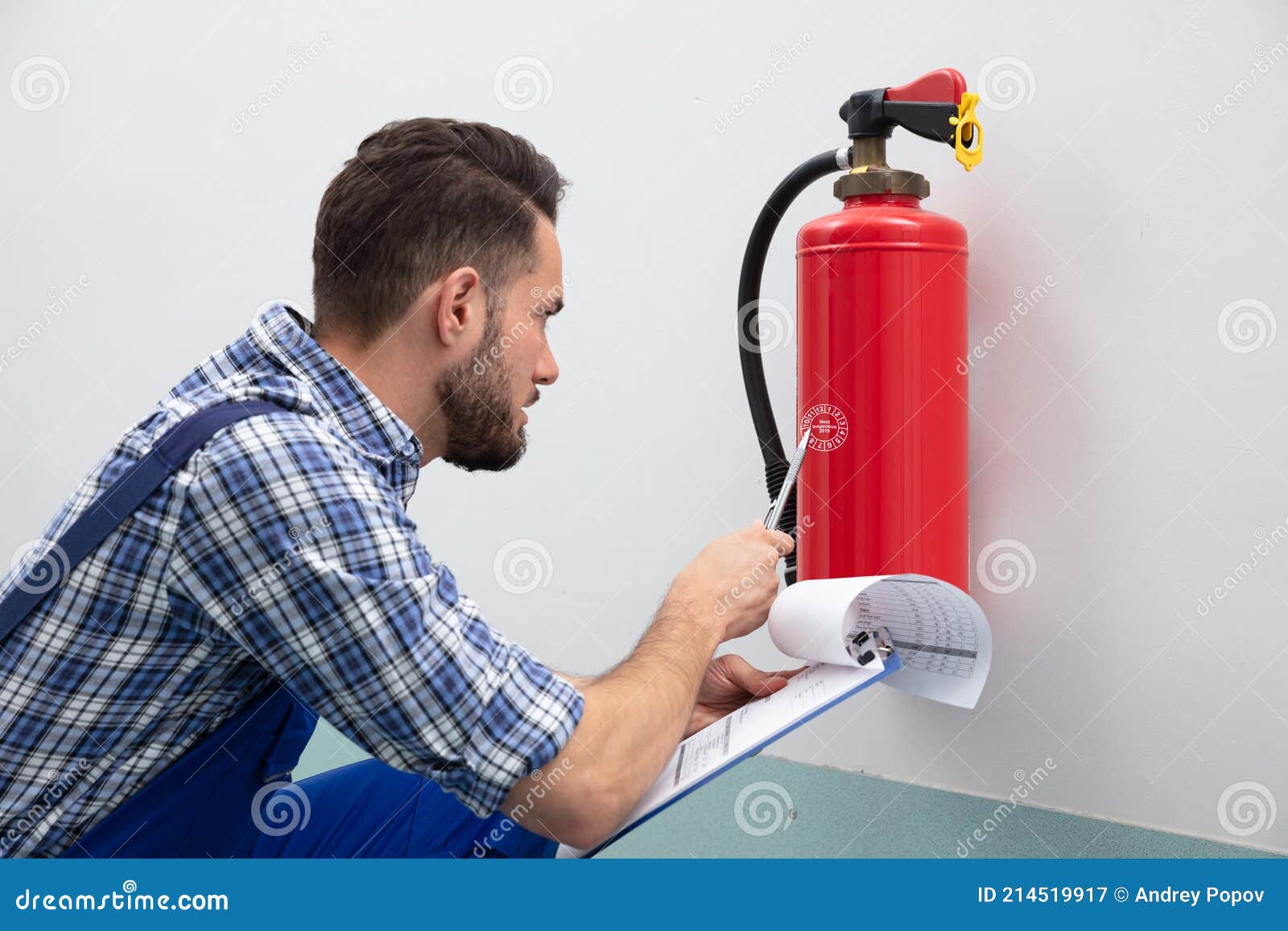 Man Checking Fire Extinguisher Writing on Document Stock Image - Image ...