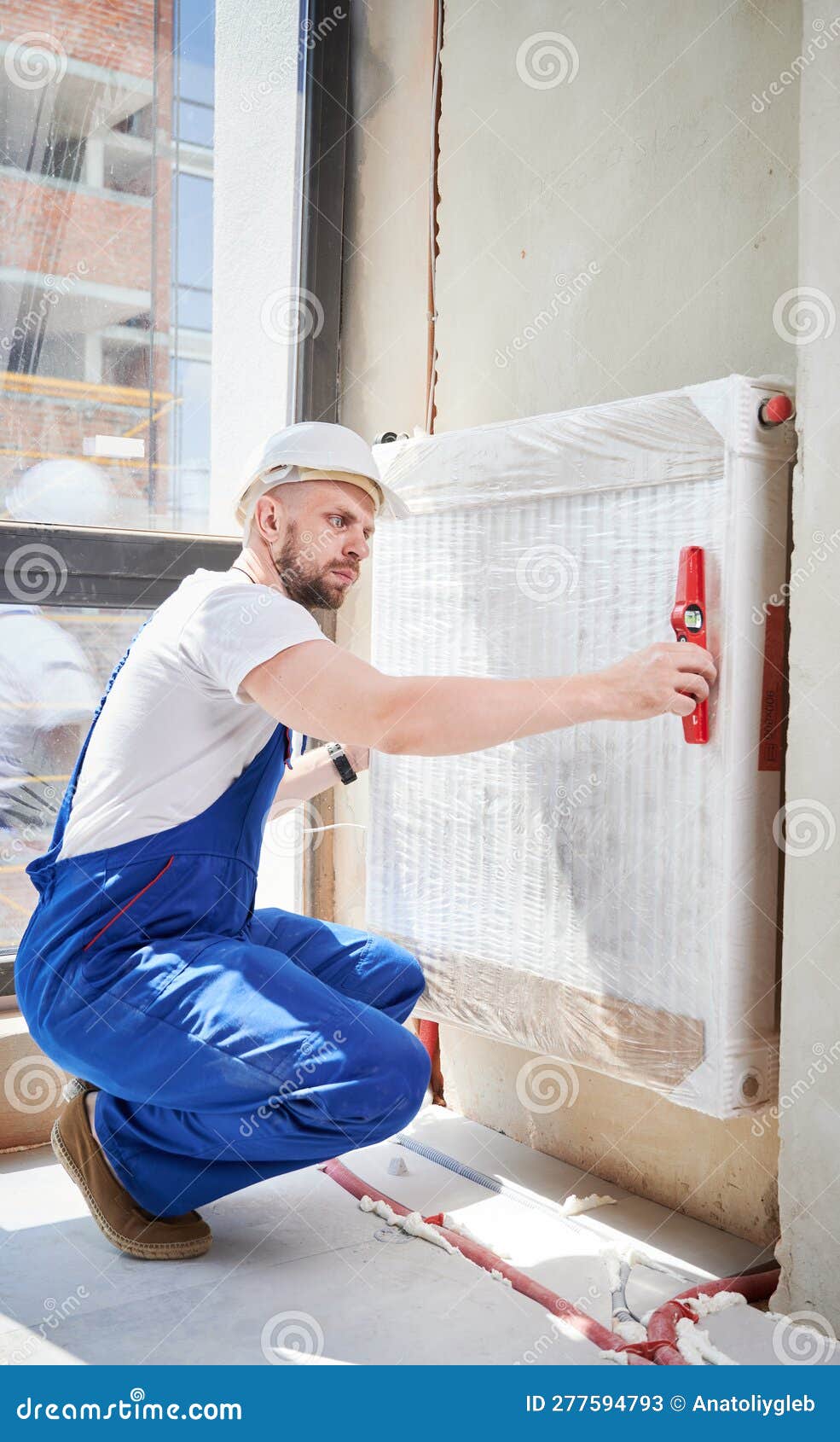 Man Checking Heating Radiator with Spirit Level Tool in Apartment ...