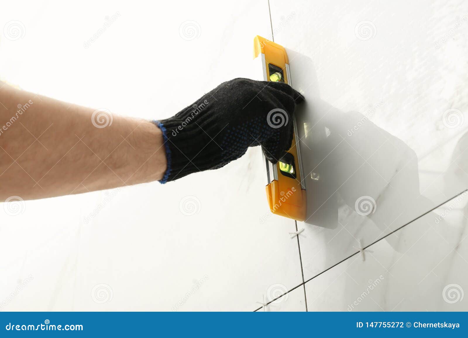 Man Checking Proper Ceramic Tile Installation with Level on Wall ...