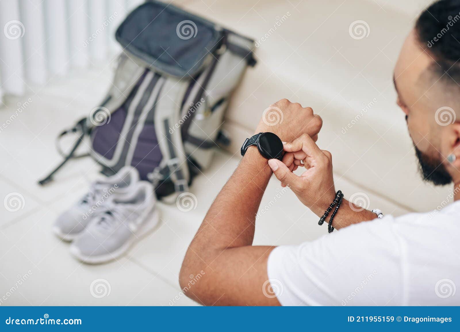 Man checking smartwatch stock image. Image of apartment - 211955159