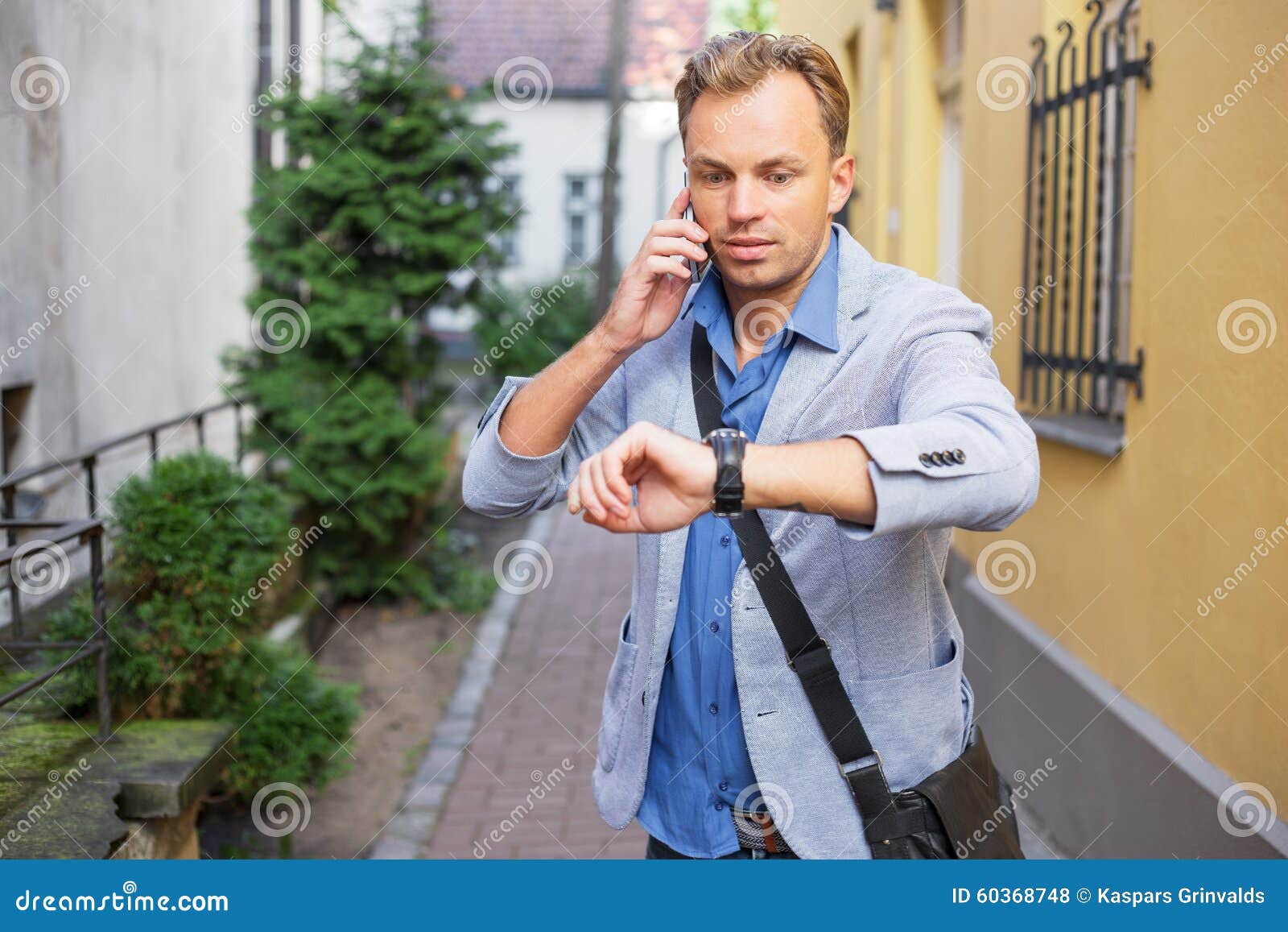 Man Checking Time on His Watch and Talking on the Phone Stock Photo ...