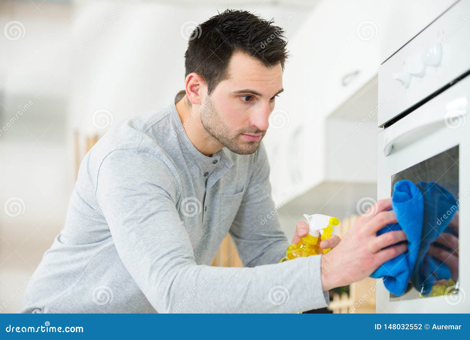 Man cleaning oven at home stock photo. Image of indoors - 148032552