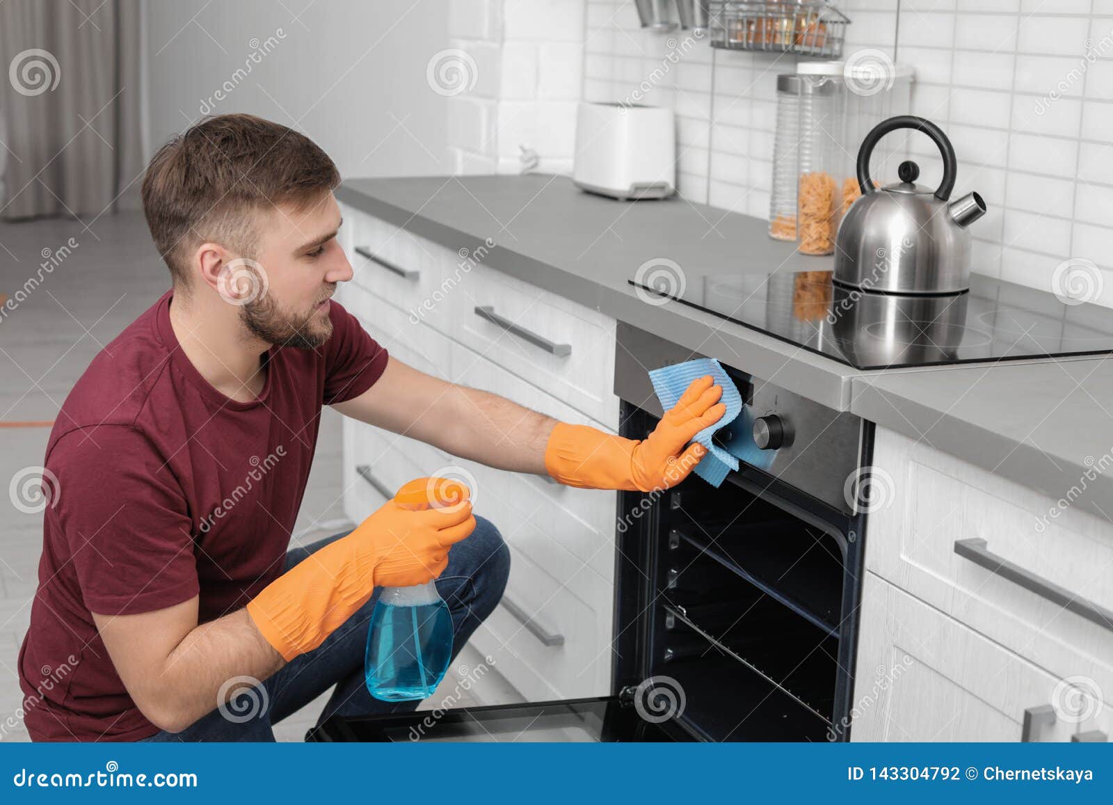 Man Cleaning Oven with Rag and Detergent in Kitchen Stock Photo - Image ...