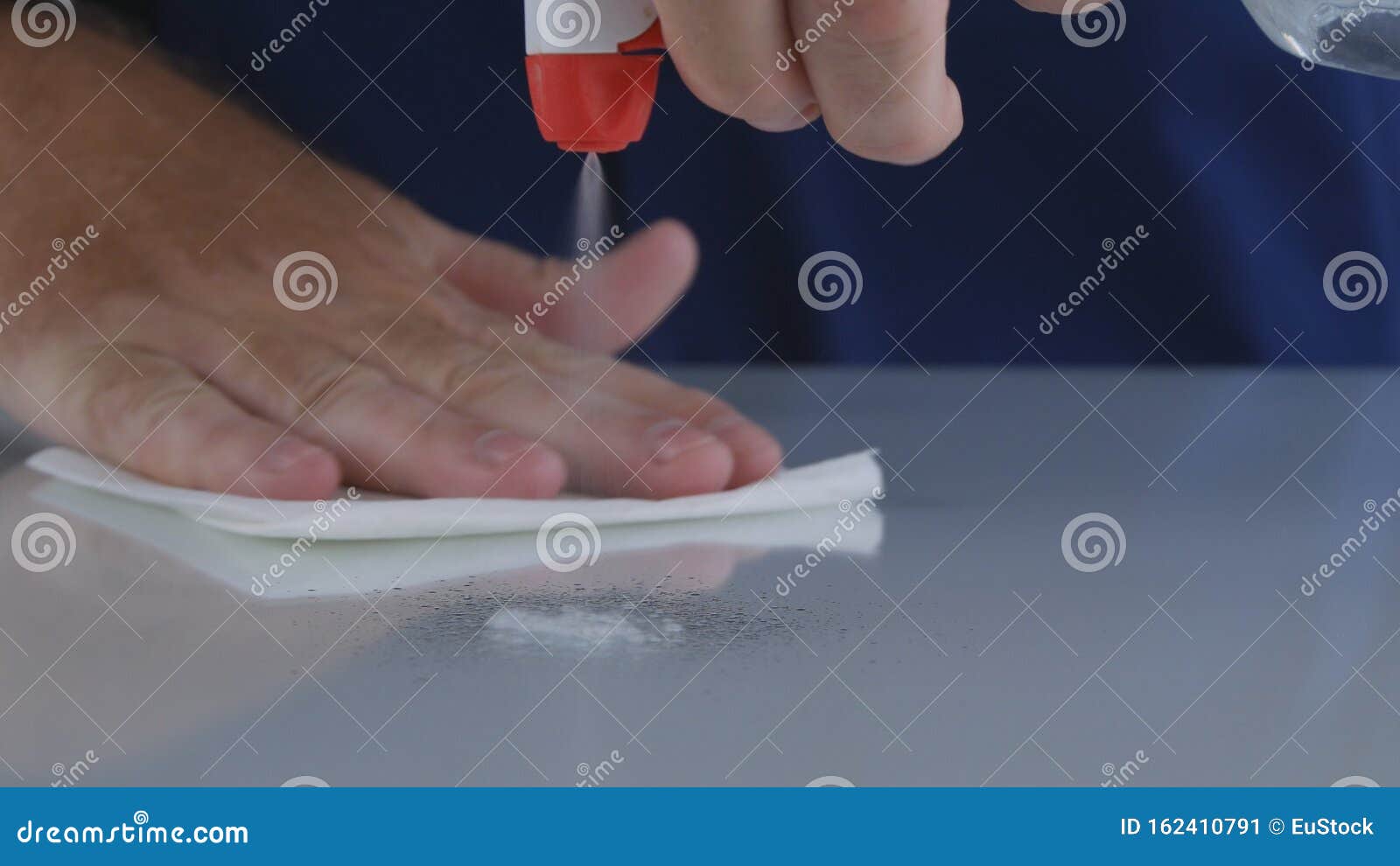 Man Cleaning Table Glass Surface with a Wet Wipe and a Spray Stock ...