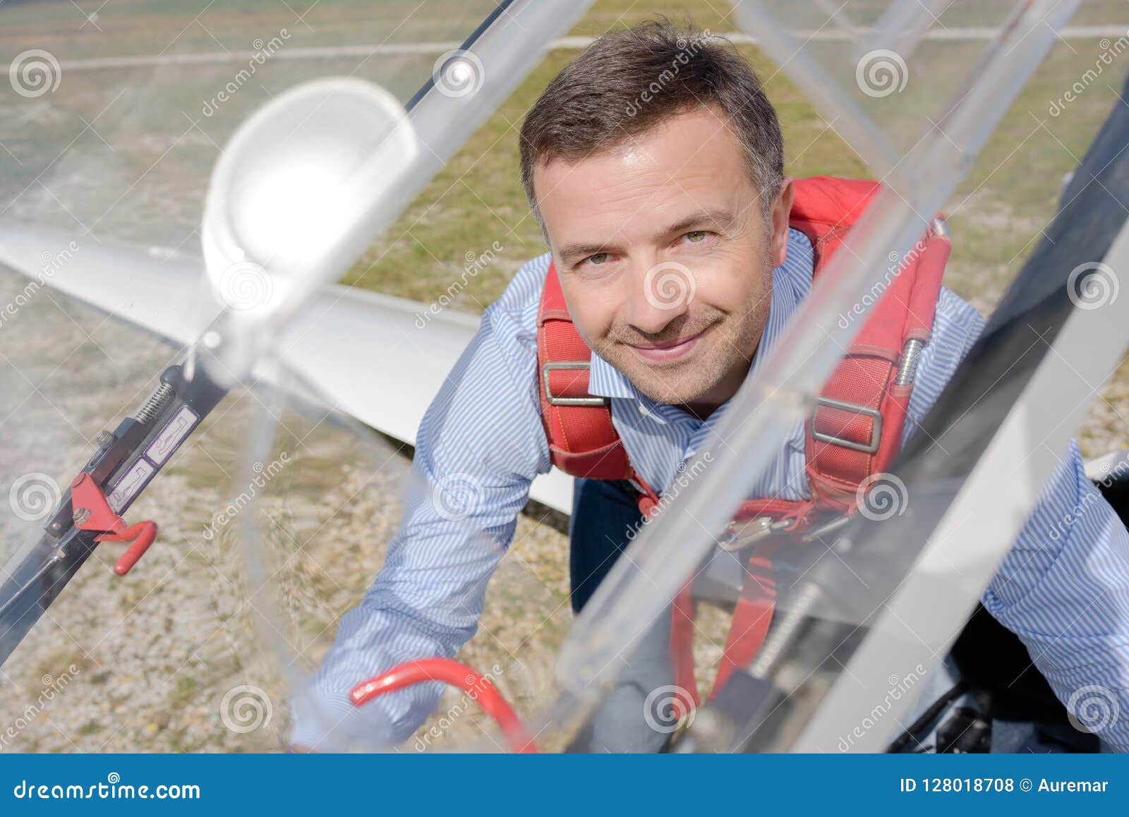 Man climbing into glider stock photo. Image of safety - 128018708