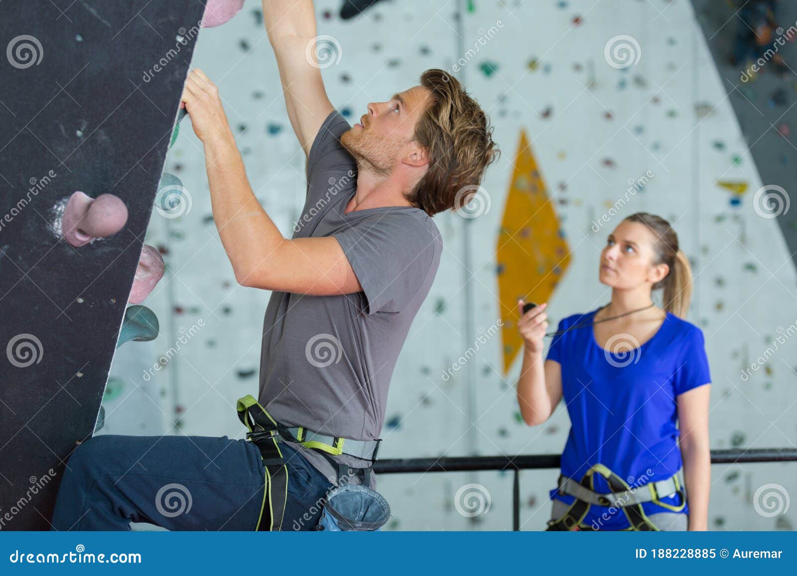 Man Climbing Indoor Wall Being Timed by Coach with Stopwatch Stock ...