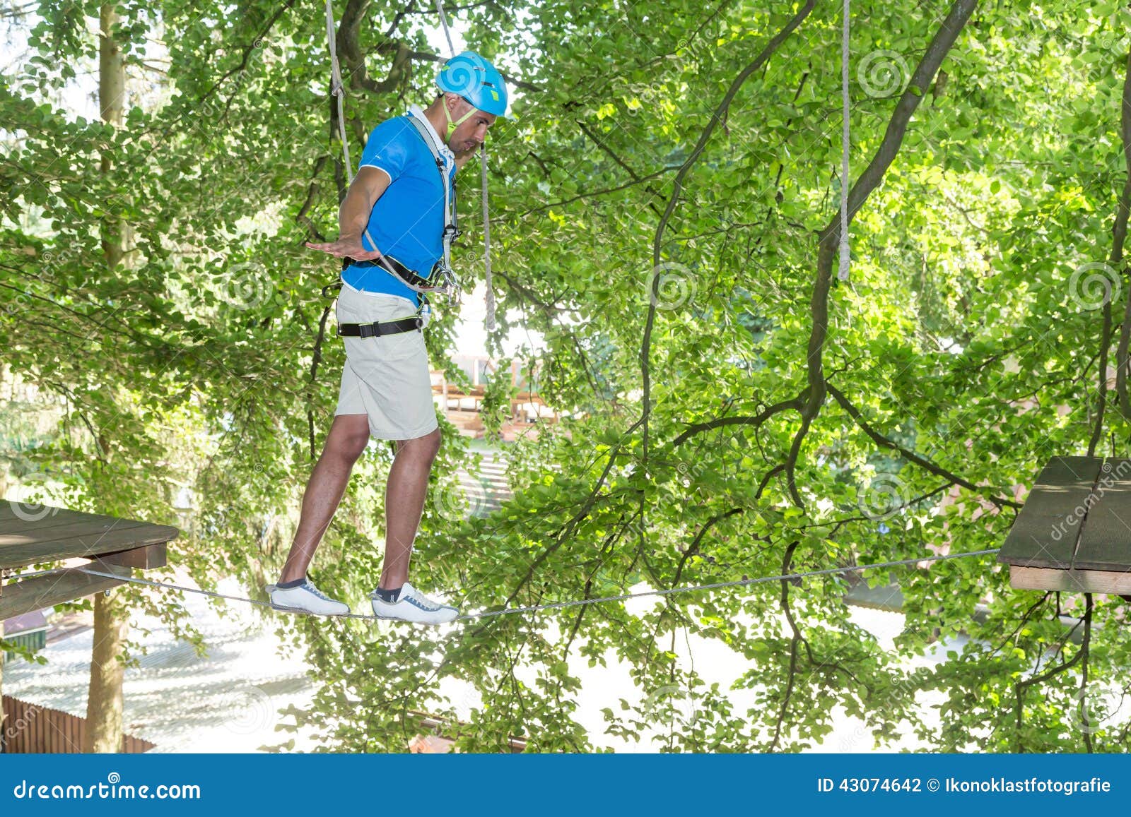 Man Climbs on Tightrope in High Rope Course Stock Photo - Image of ...