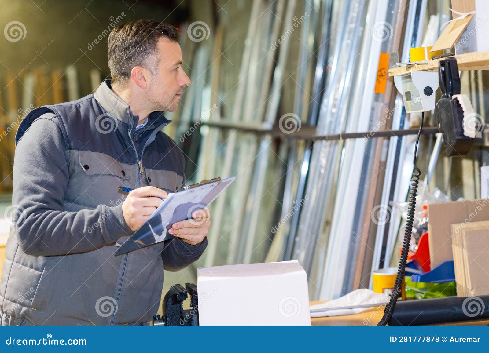 Man with Clipboard in Factory Preparaing Parcel for Despatch Stock ...