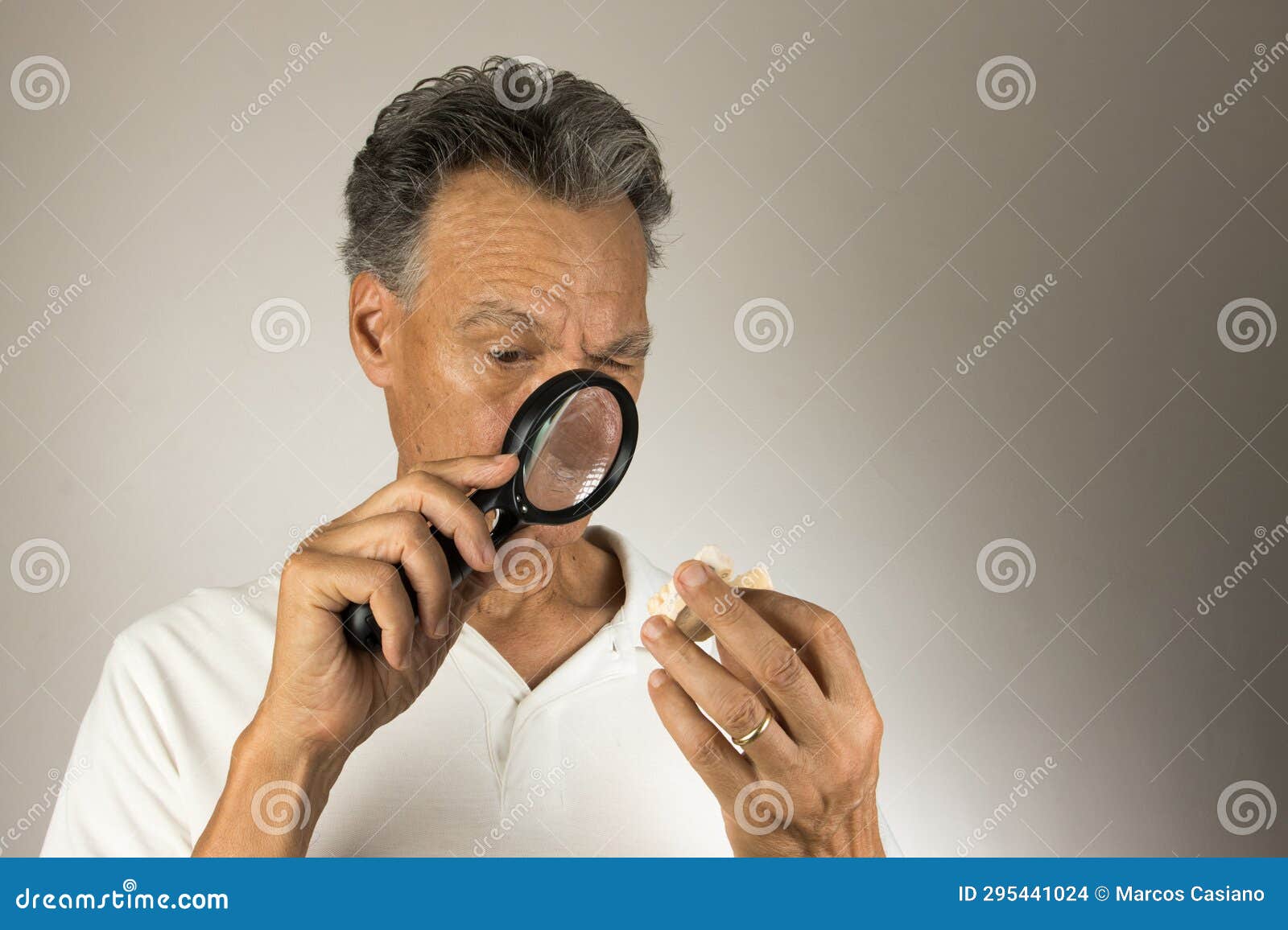 Man Closely Examining the Mold of His Lower Teeth Stock Photo - Image ...