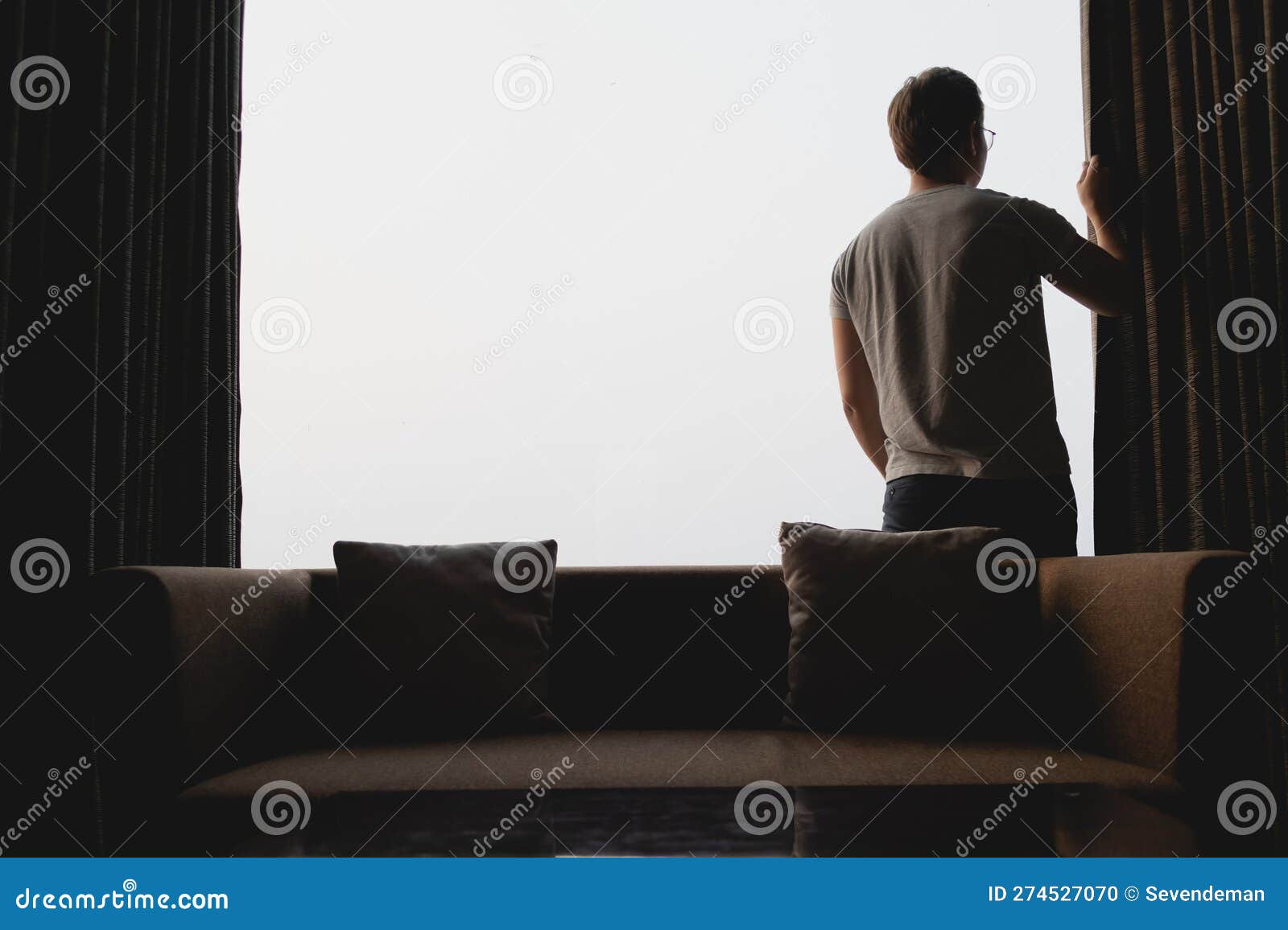 Man Closing the Curtain while Watching the View Out of the Window ...
