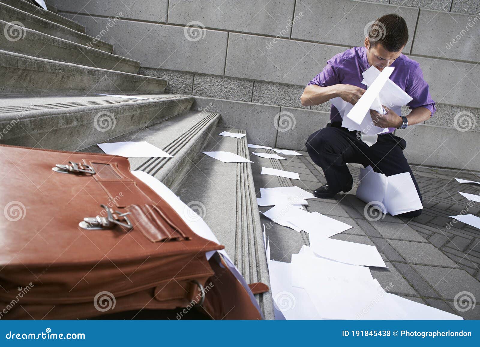 Man Collecting Spilled Paperwork from Steps Stock Photo - Image of ...