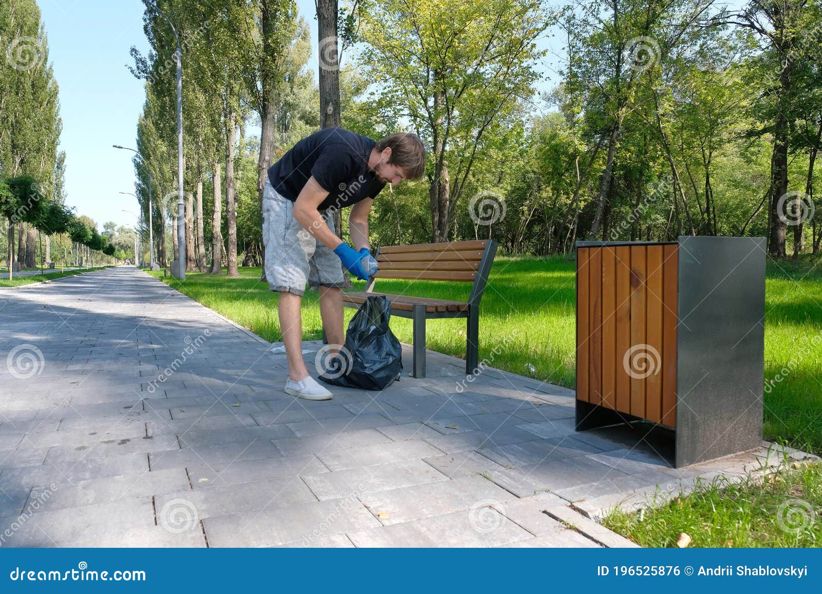 A Man Collecting Trash in a Black Bag. Cleaning in the Public Park ...