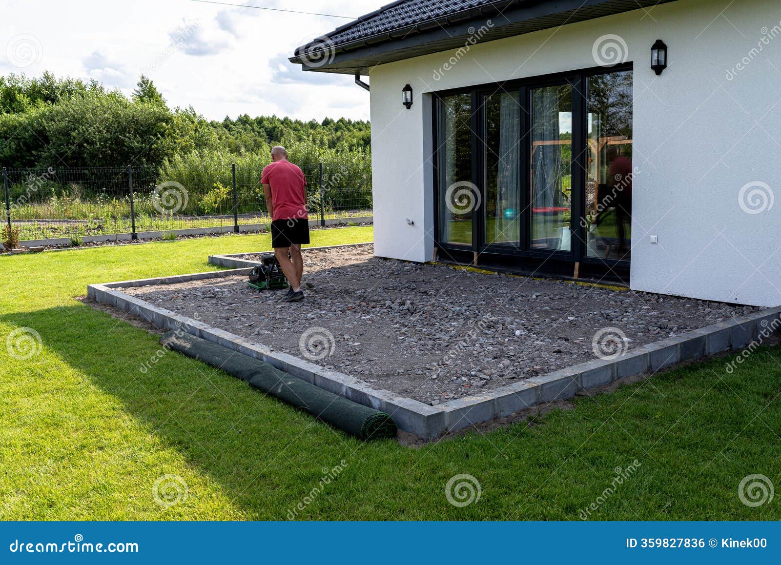 A Man Compacts Rubble on a Terrace Under Construction Using a Hand-held ...
