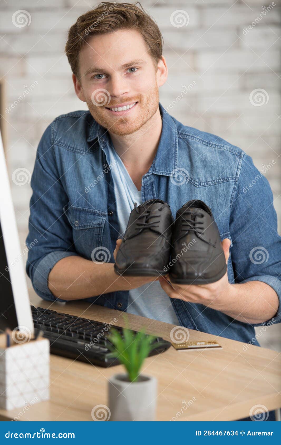 Man at Computer Desk Holding Pair New Shoes Stock Photo - Image of ...