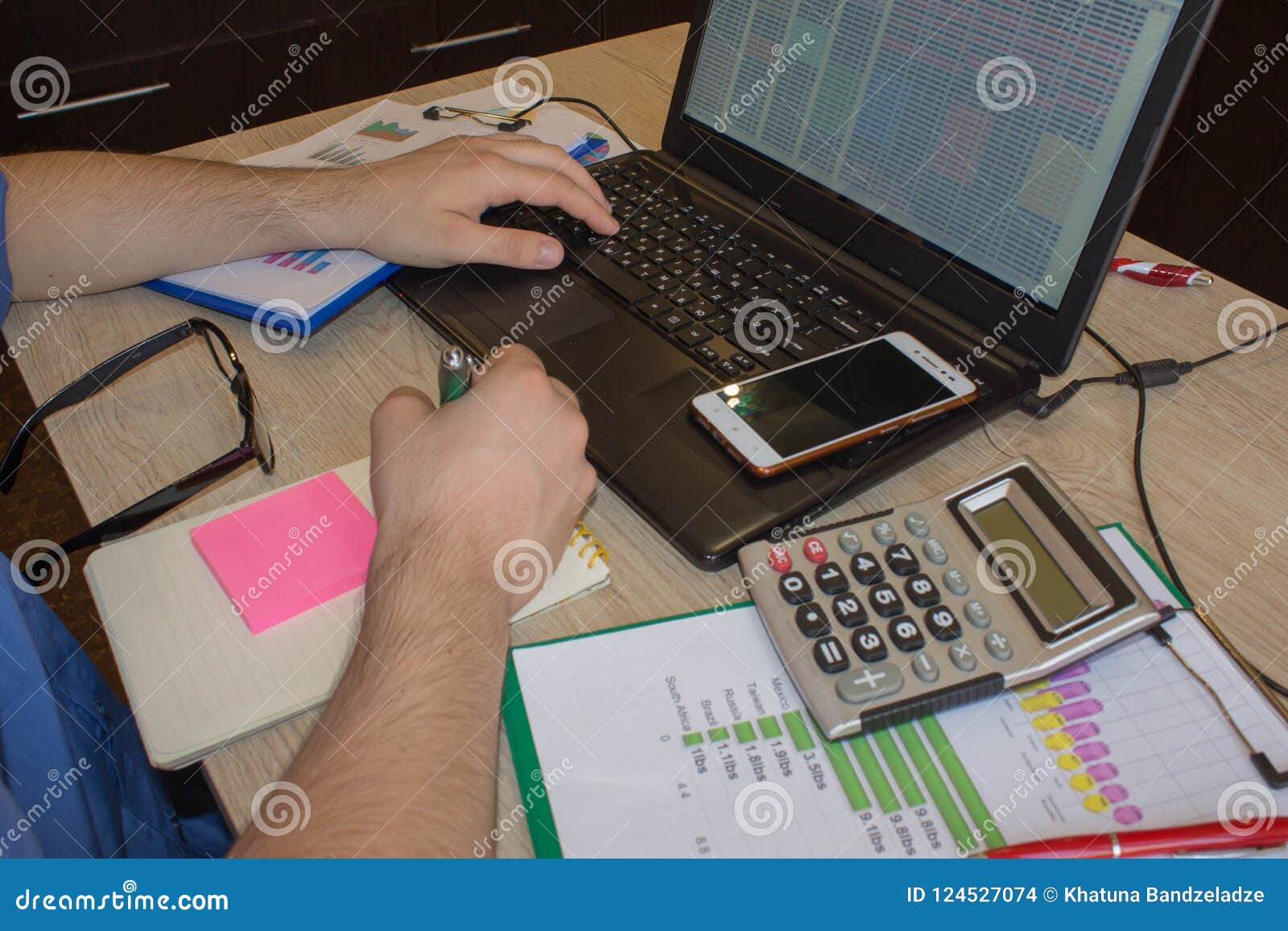The Man and Computer are Using a Calculator on the Table in the Office ...