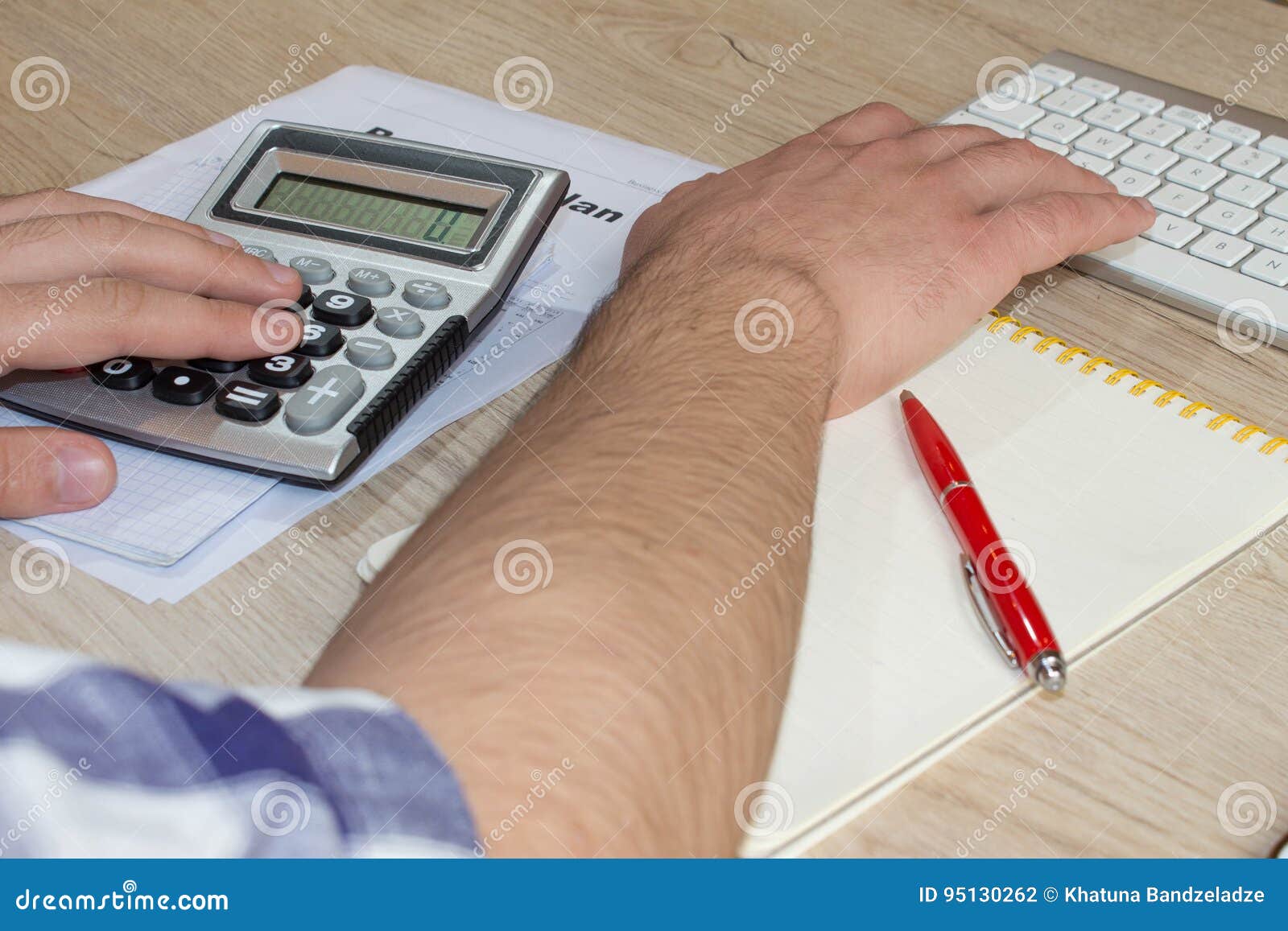 The Man and Computer are Using a Calculator on the Table in the Office ...