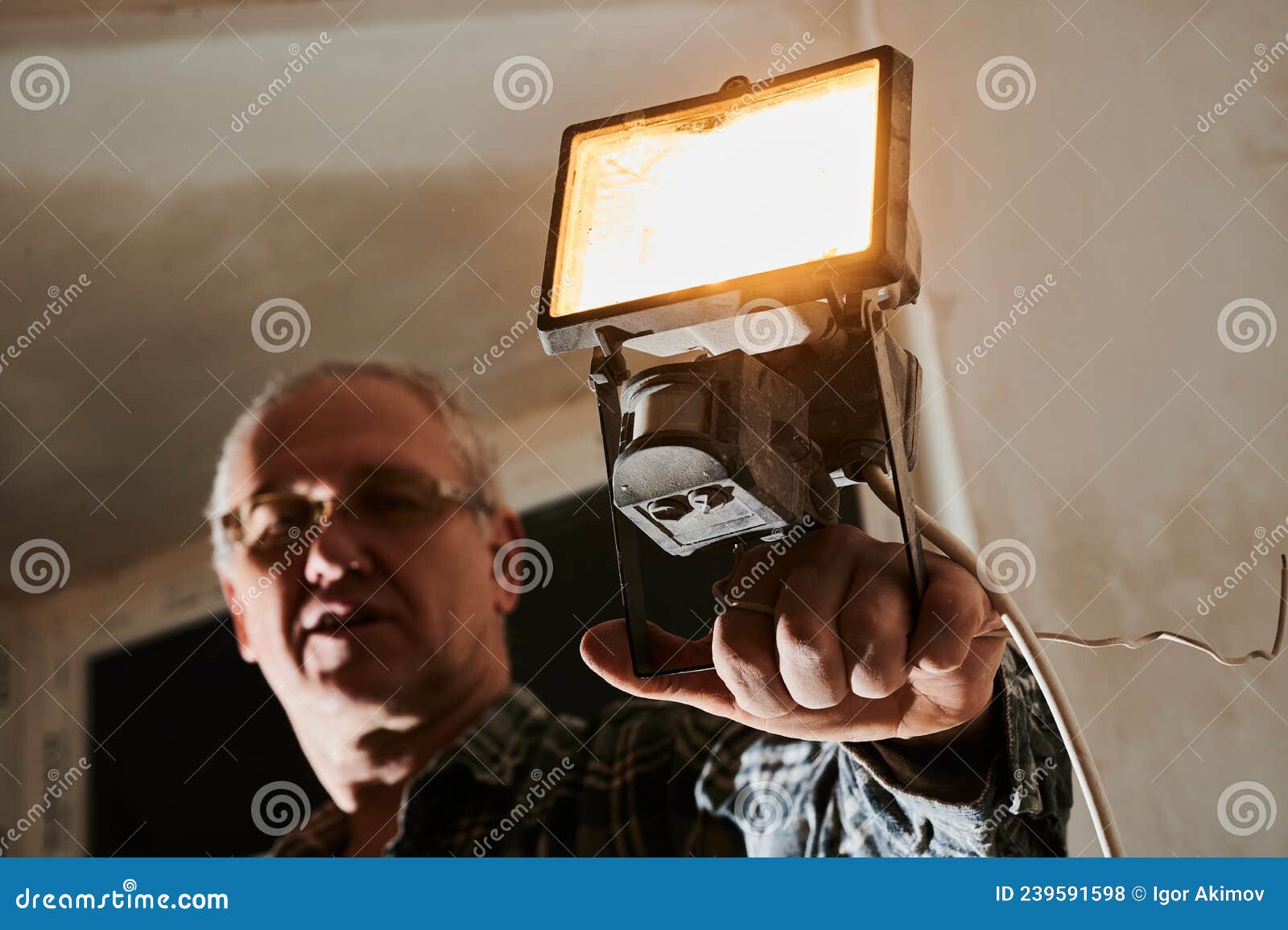 A Man at a Construction Site Demonstrates a Lantern that he Uses To ...