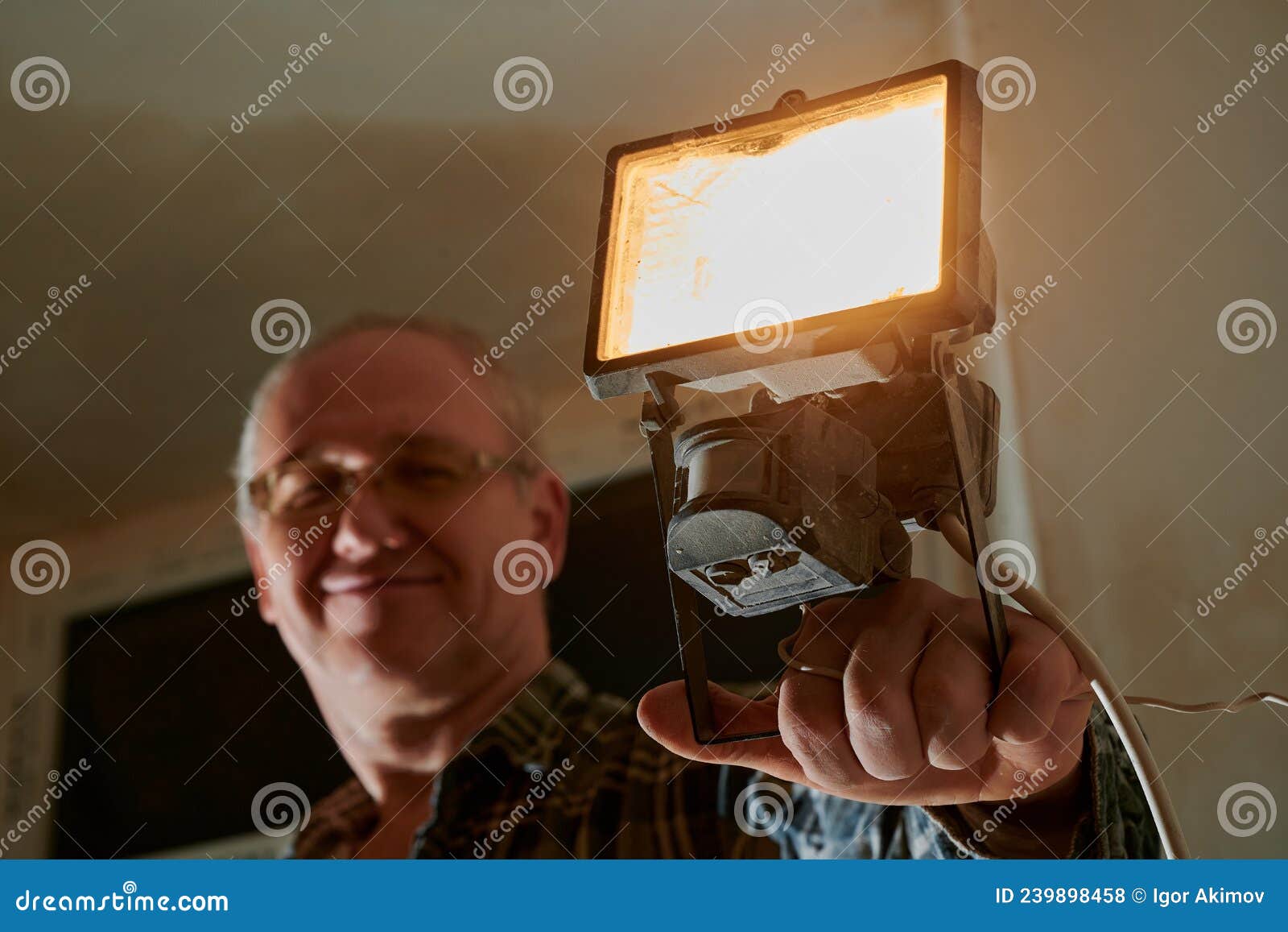A Man at a Construction Site Demonstrates a Lantern that he Uses To ...