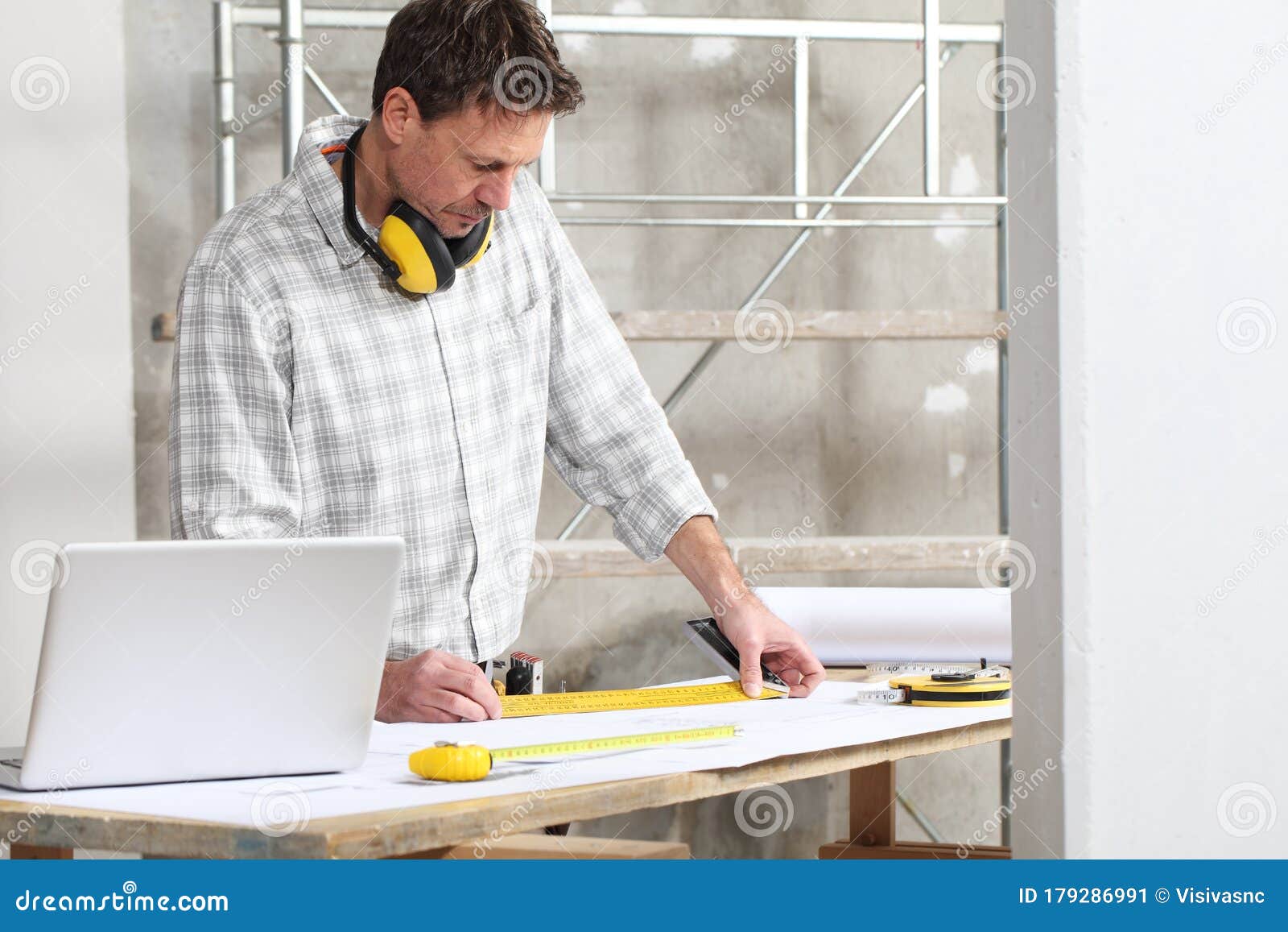 Man Construction Worker Takes the Measures of the Project at Interior ...