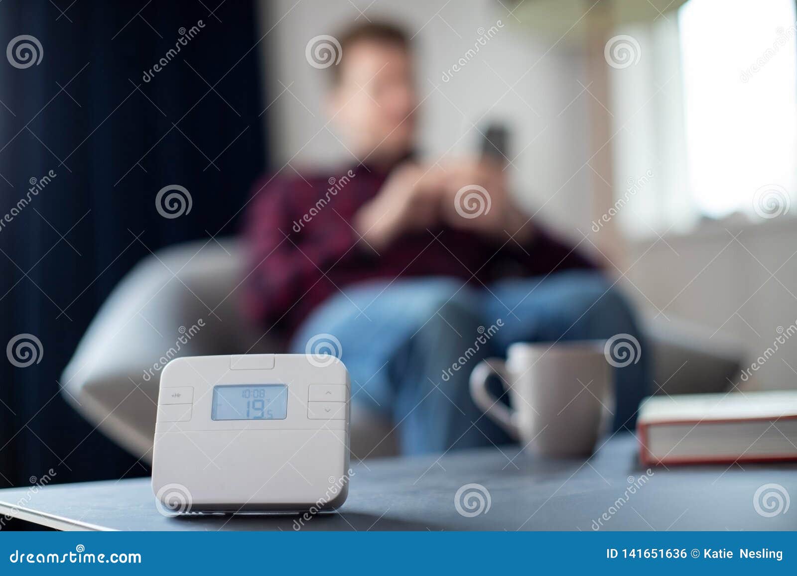 Man Controlling Central Heating Smart Meter Using App on Mobile Phone ...