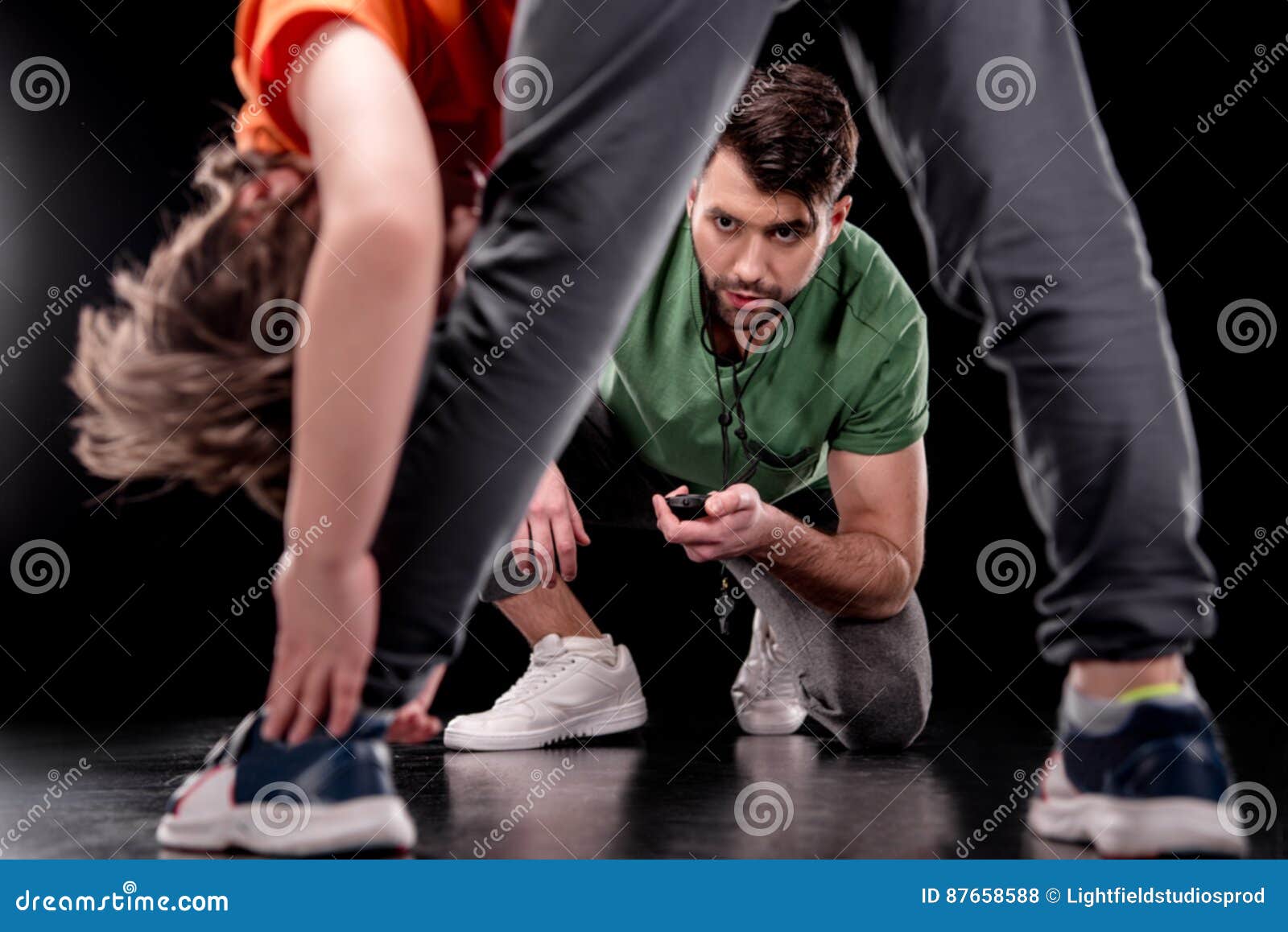 Man Controlling Time while Boy Doing Exercise on Black, Stock Photo ...