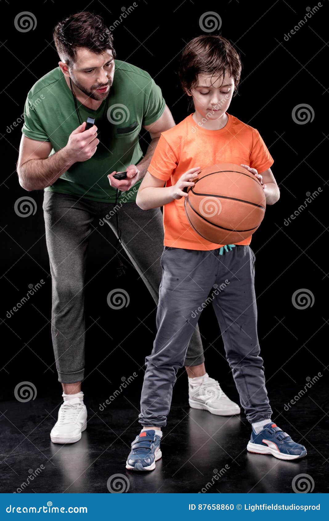 Man Controlling Time while Boy Training with Basketball Ball Stock ...