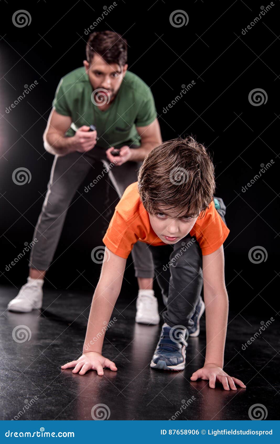 Man Controlling Time while Boy Training and Looking To Camera Stock ...
