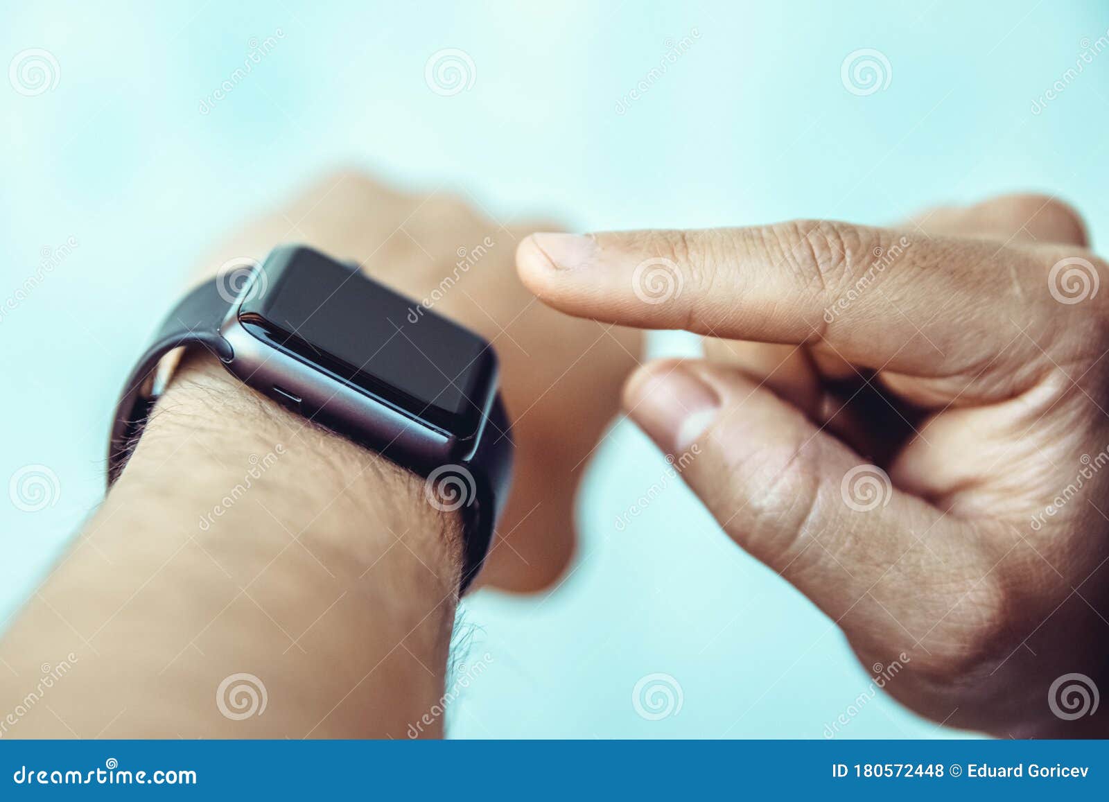 The Man Controls by Touching His Finger a Smart Watch on His Hand Stock ...