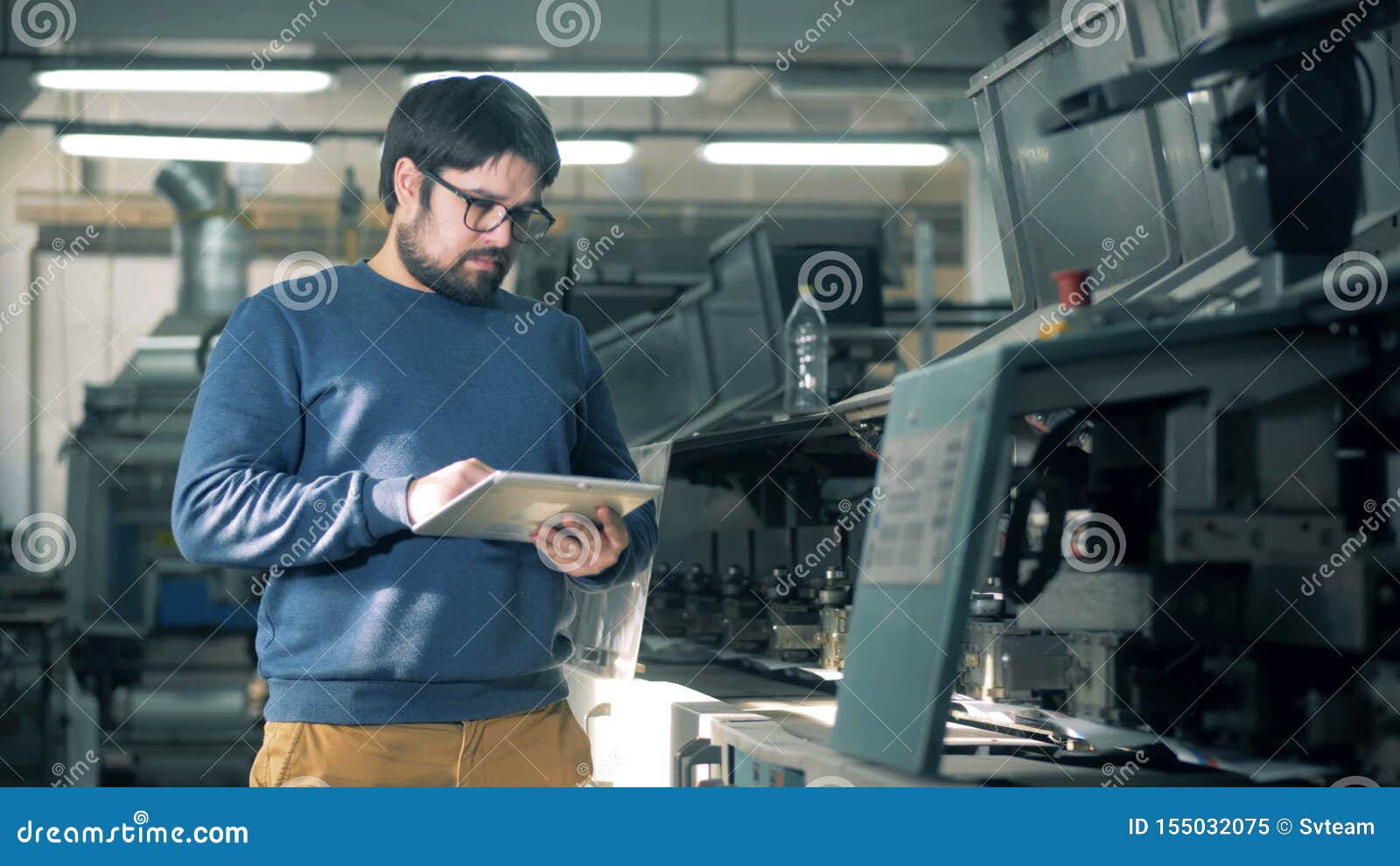 Man Controls the Work of Typographic Conveyor, Typing on a Tablet ...
