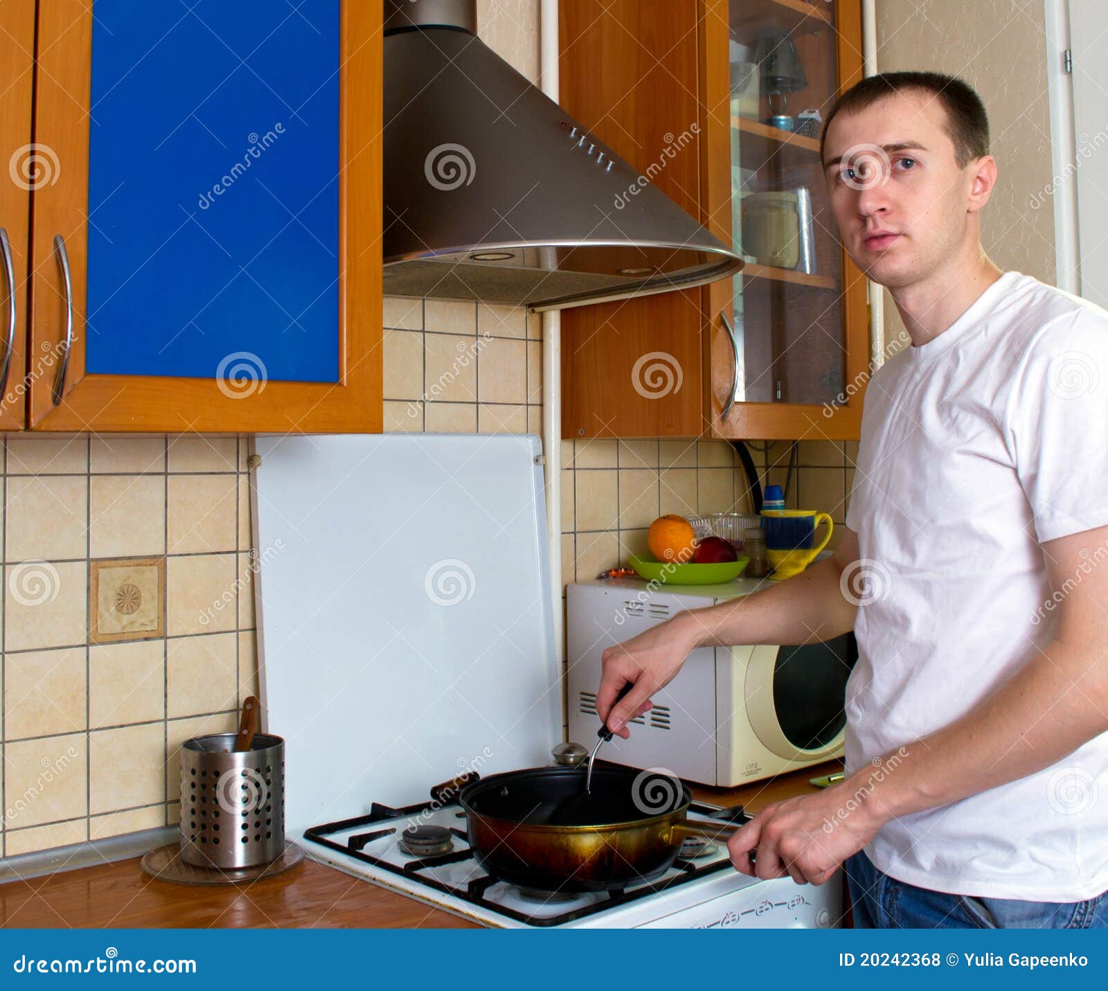 Man cooking at the kitchen stock photo. Image of recipes - 20242368