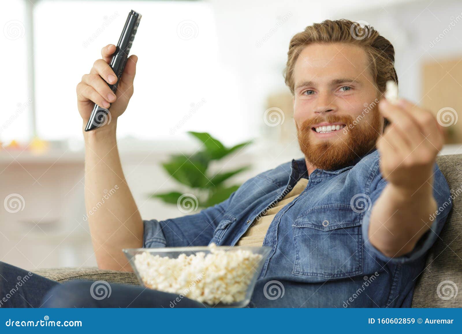 Man on Couch Showing Popcorn he Snacking on Stock Image - Image of show ...